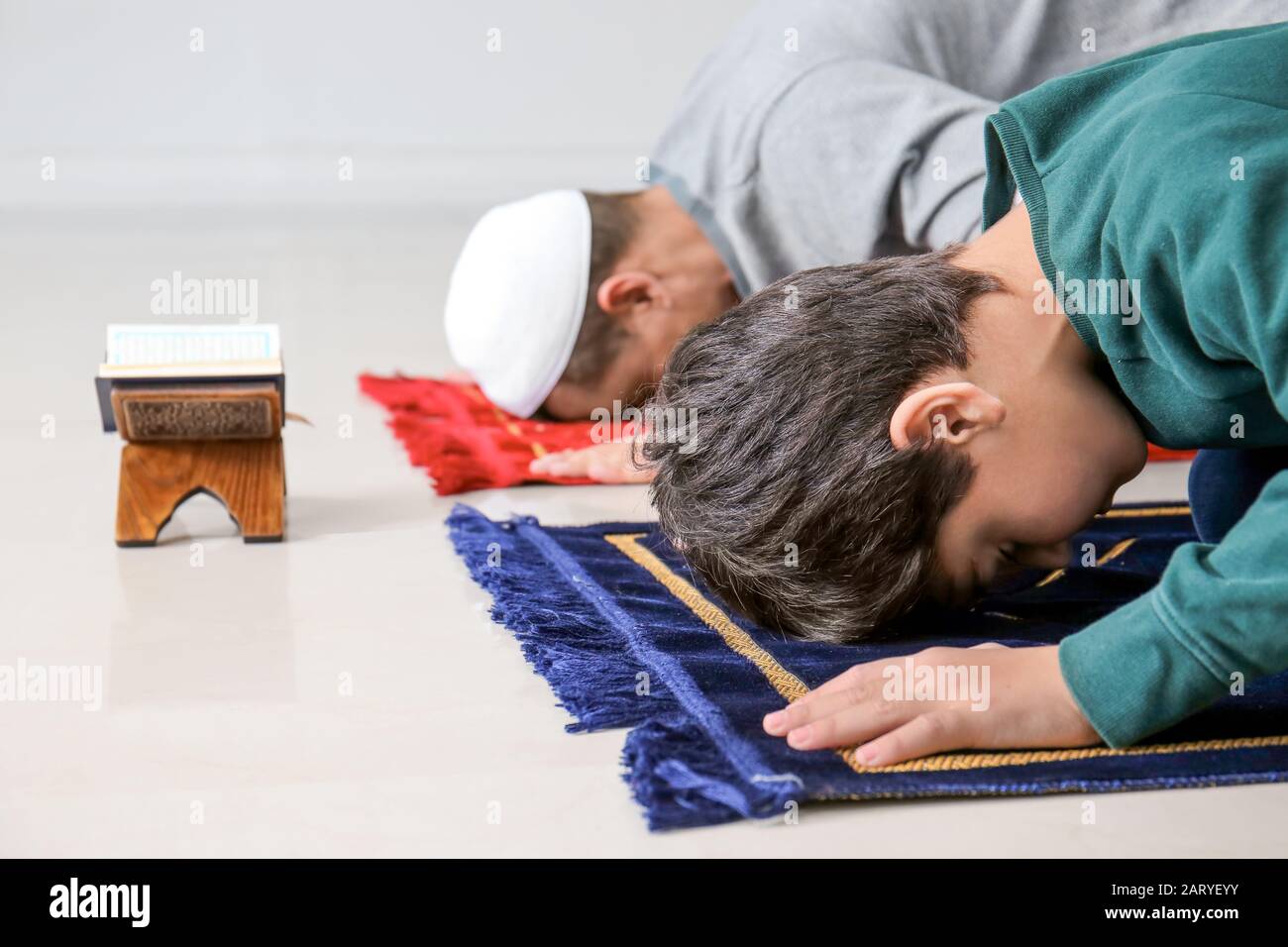 Muslim boy with father praying indoors Stock Photo - Alamy