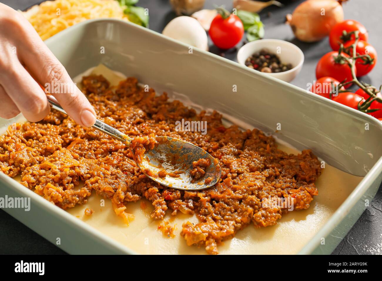 Woman cooking tasty lasagna, closeup Stock Photo - Alamy