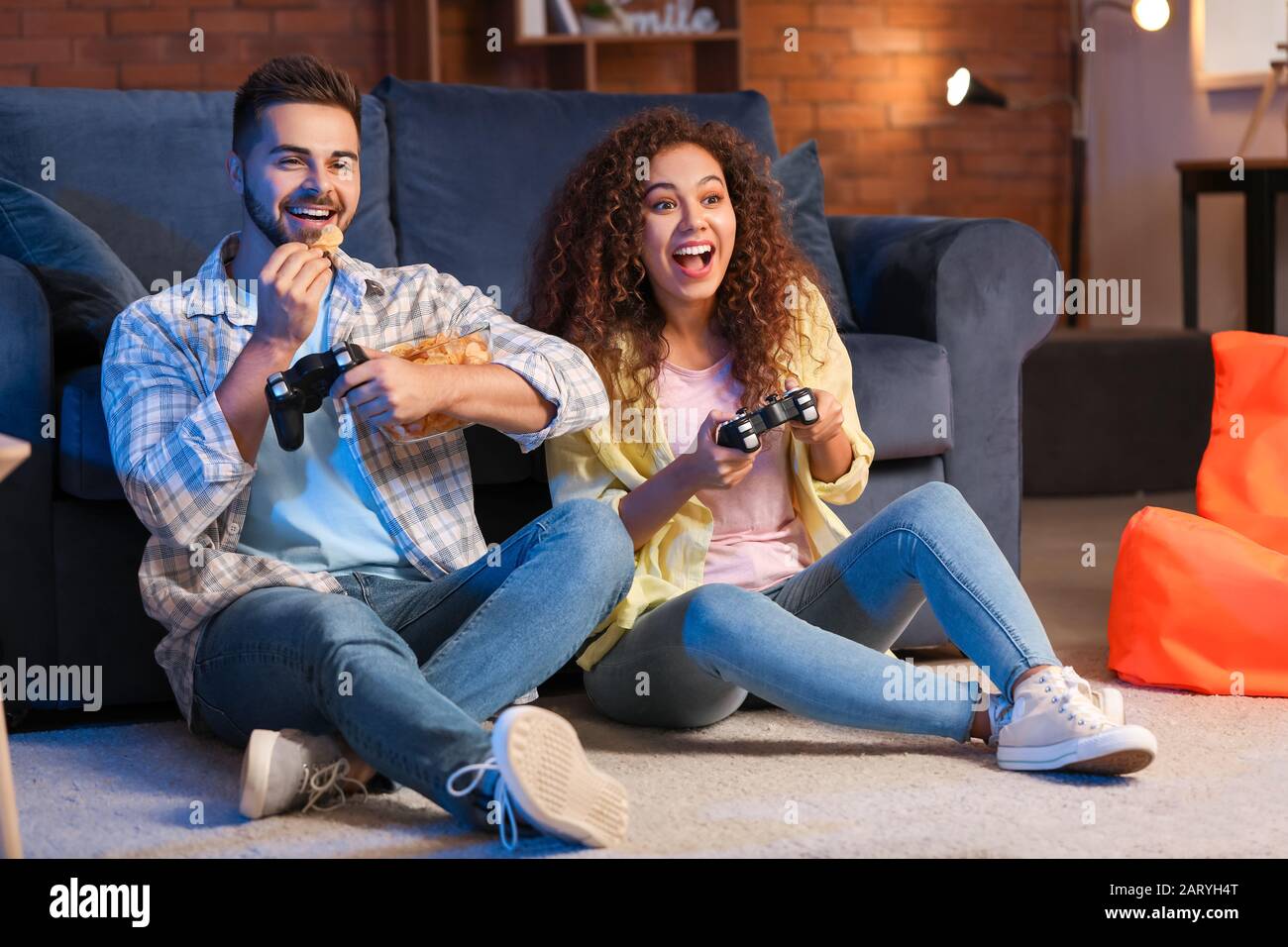 Friends playing video game at home Stock Photo - Alamy