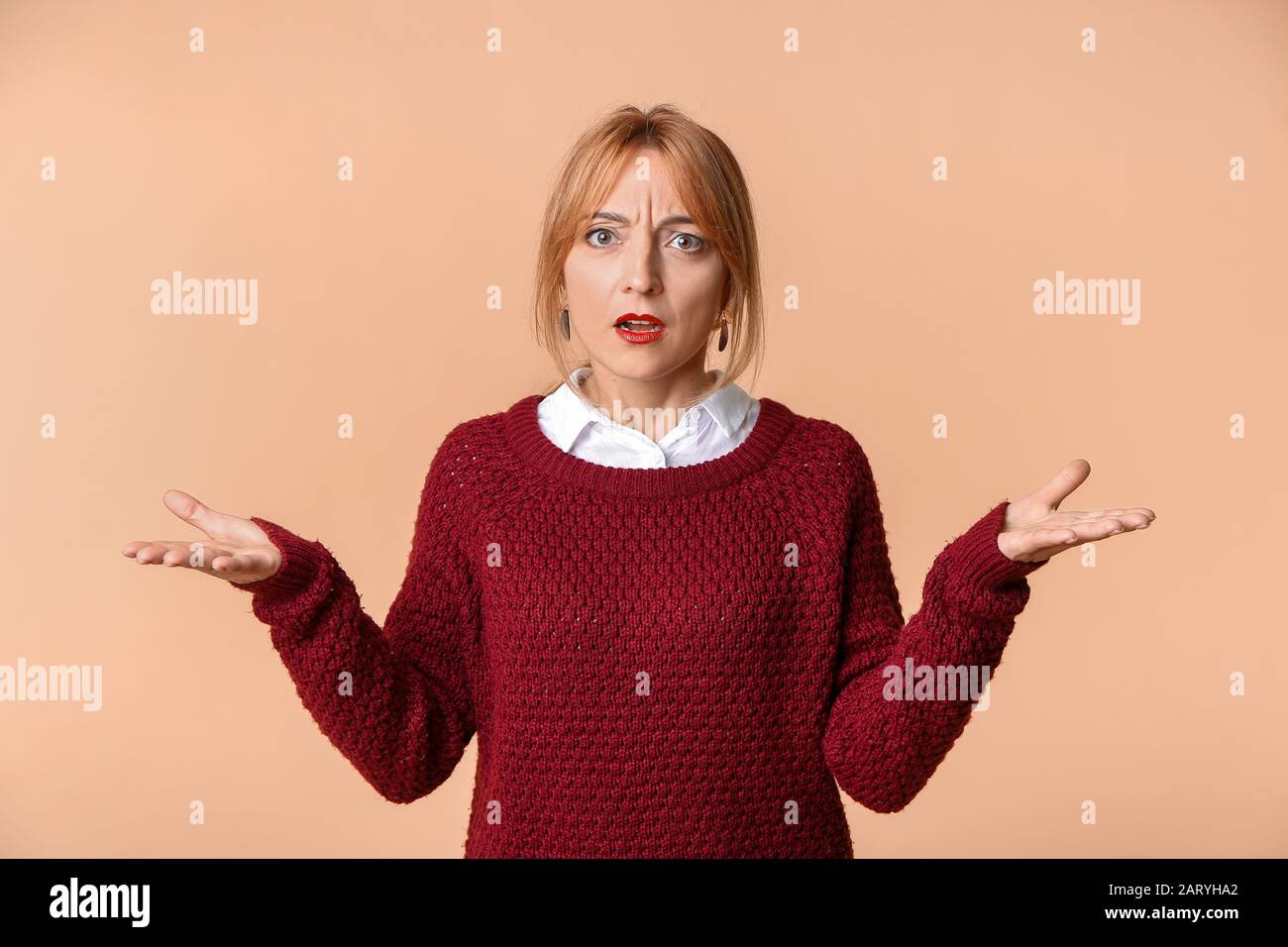 Confused mature woman on color background Stock Photo - Alamy