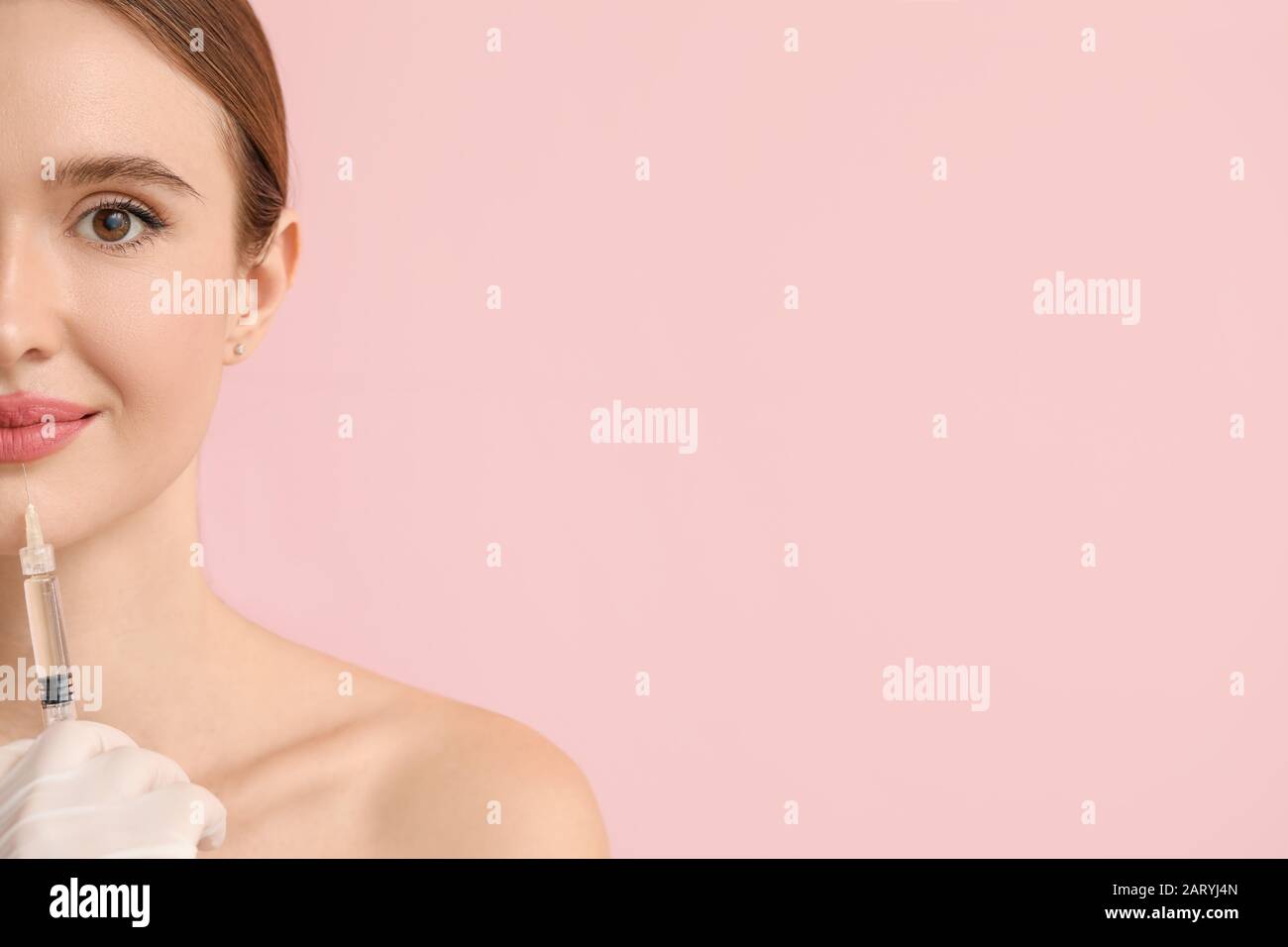 Young woman receiving filler injection against color background Stock ...