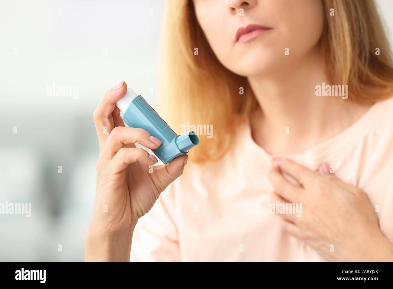 Beautiful mature woman with asthma inhaler at home Stock Photo - Alamy