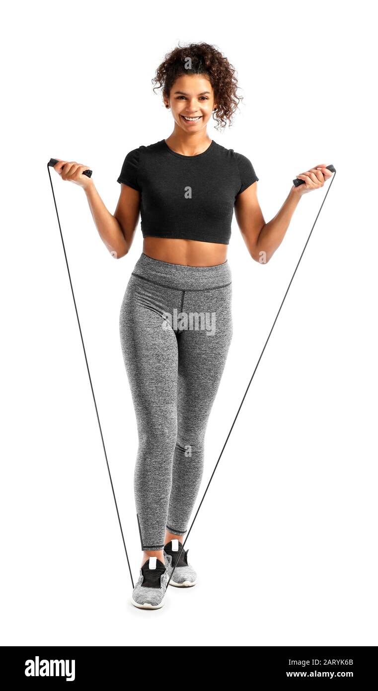 Sporty African-American woman with jumping rope on white background ...