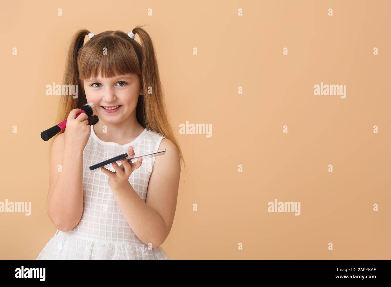 Cute little girl with cosmetics on color background Stock Photo - Alamy