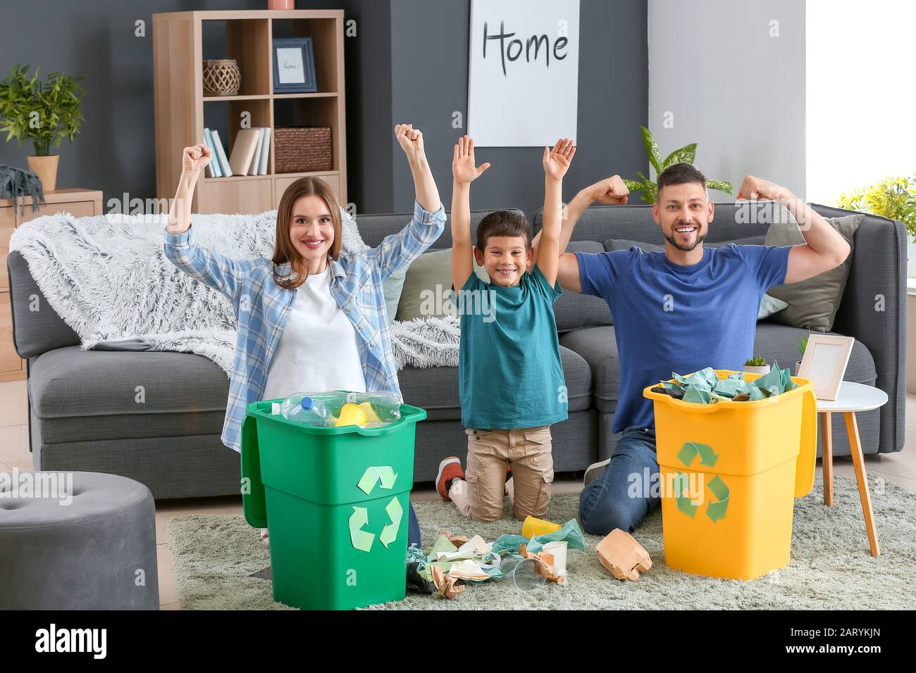 Happy family sorting garbage at home. Concept of recycling Stock Photo ...
