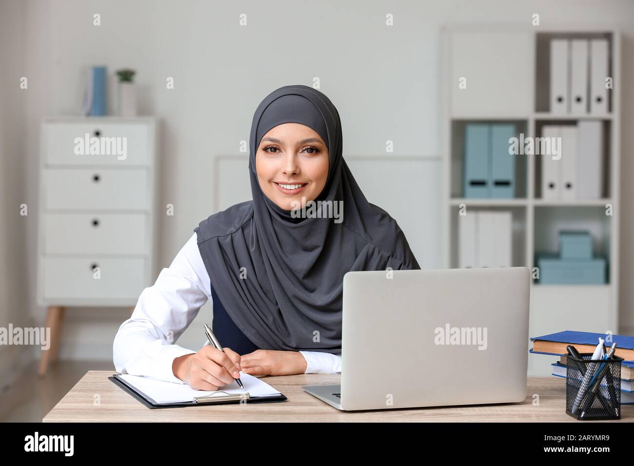 Beautiful Muslim student with laptop preparing for exam Stock Photo - Alamy