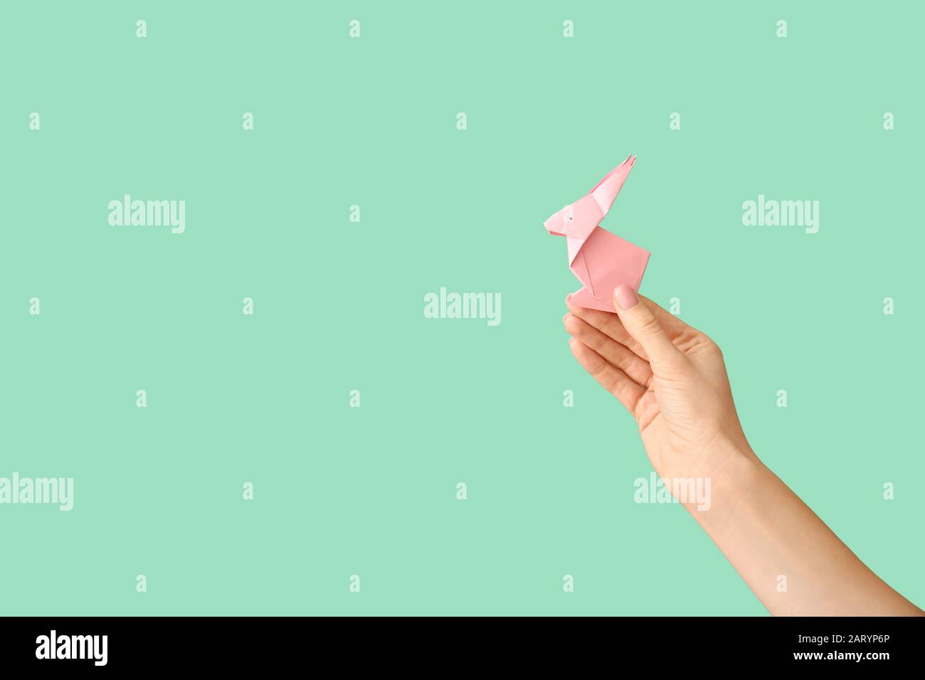 Female hand with origami rabbit on color background Stock Photo - Alamy