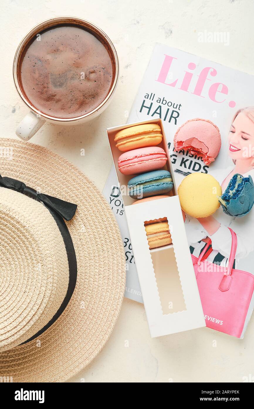 Box with different tasty macarons, cup of coffee, hat and fashion ...