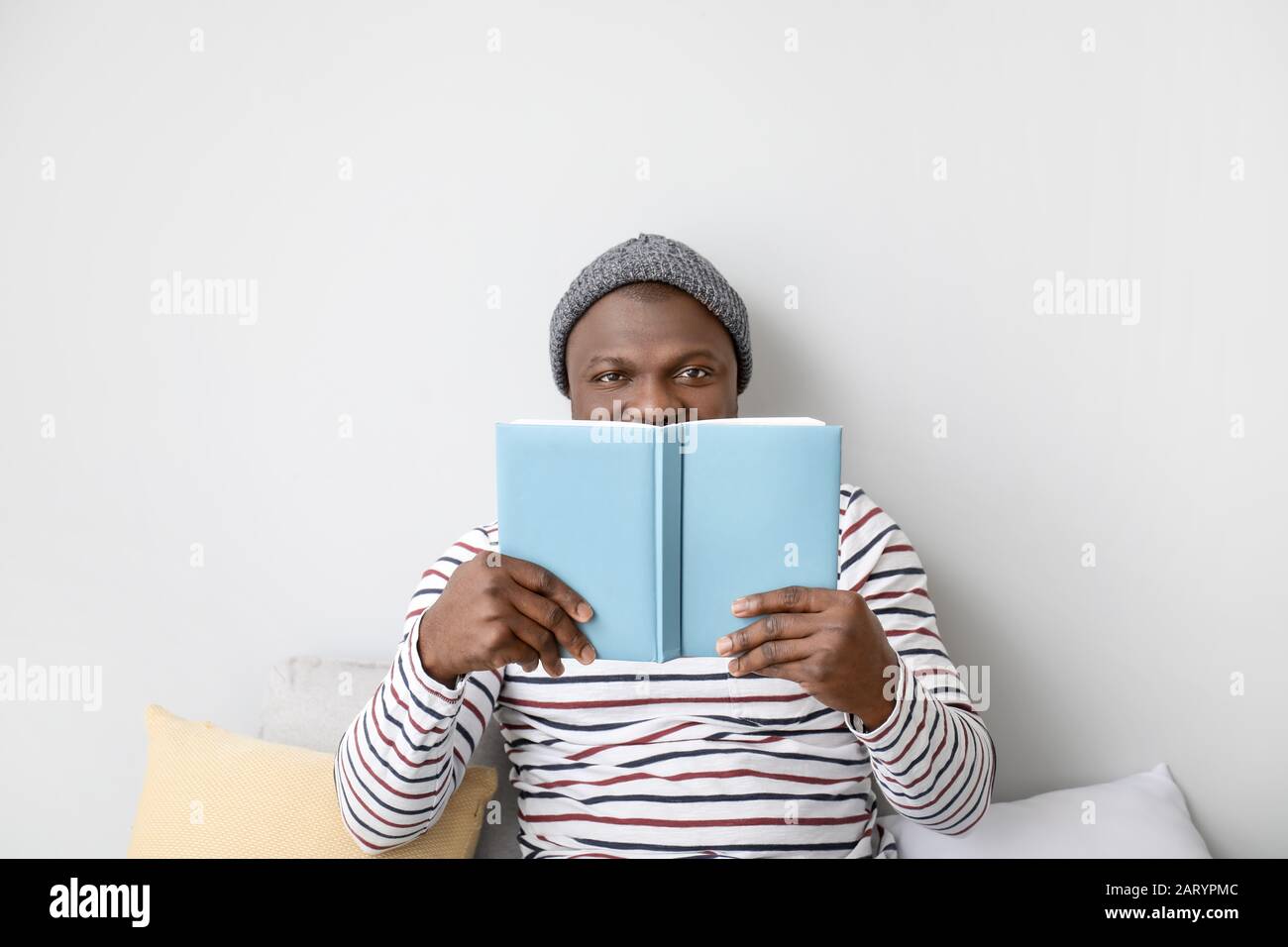 African-American man reading book on light background Stock Photo - Alamy