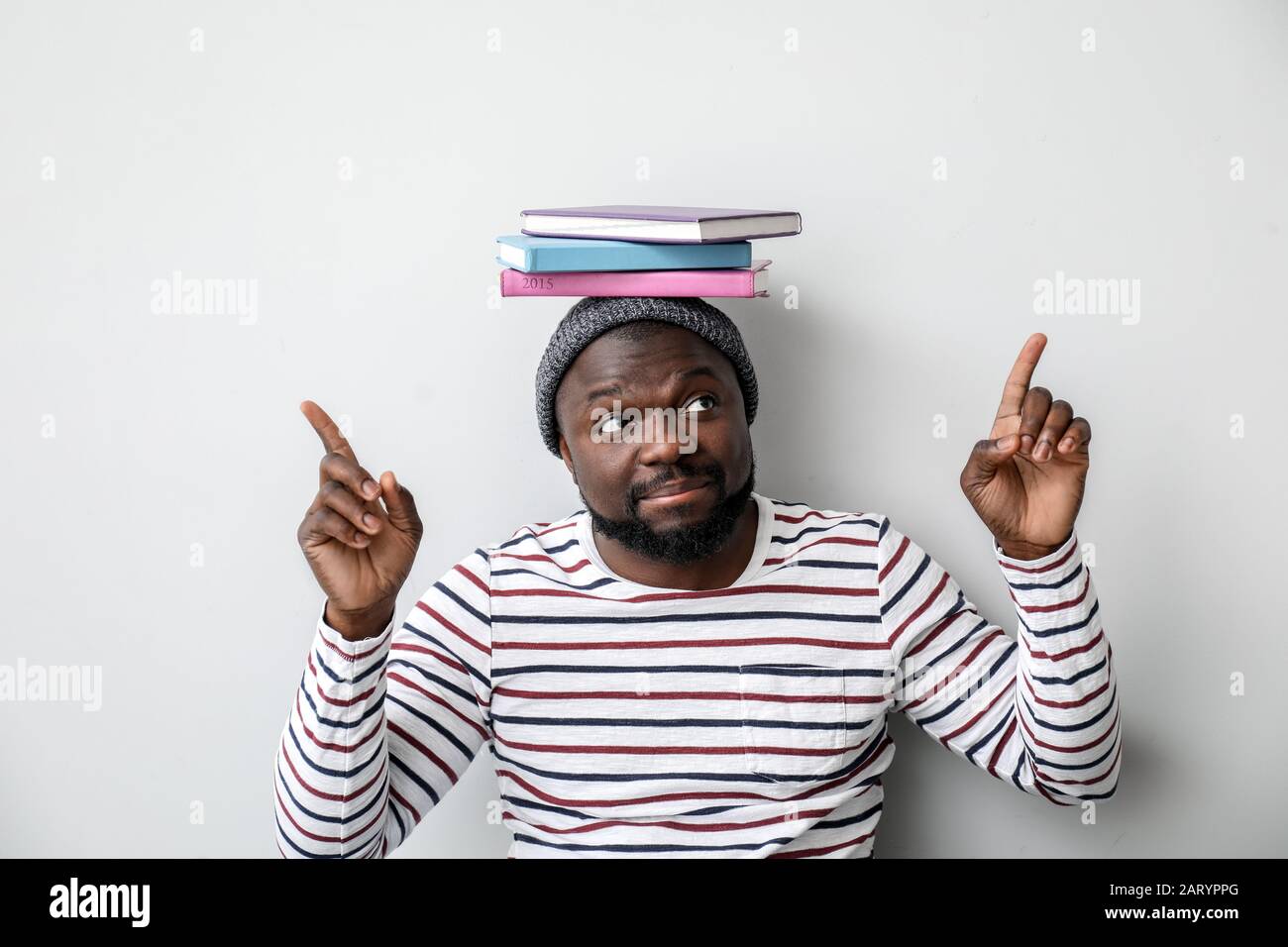 African-American man with book pointing at something on light ...