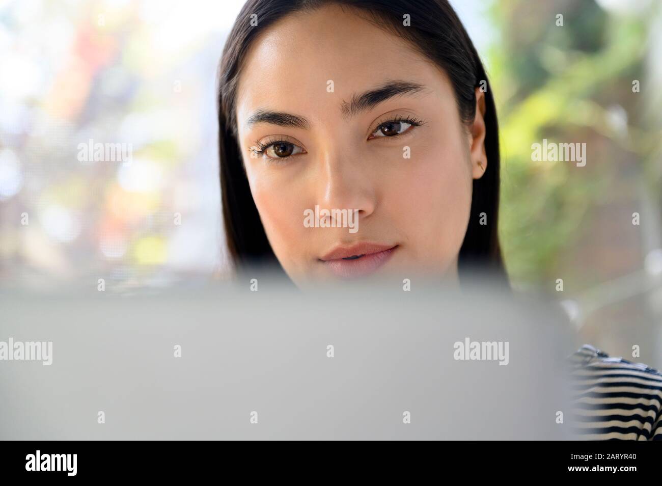 Woman with black hair behind laptop Stock Photo - Alamy