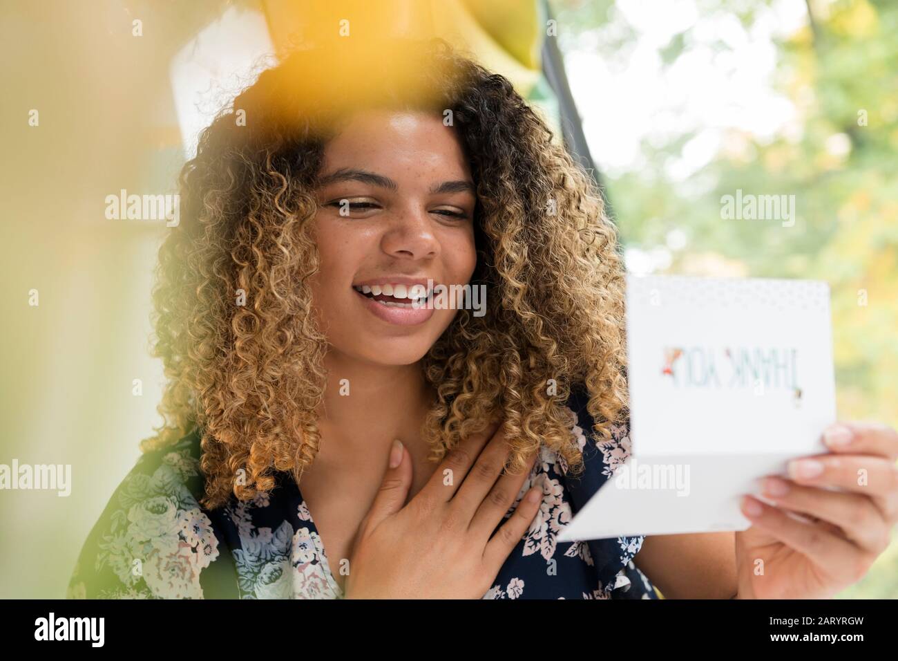 Smiling woman reading thank you card Stock Photo - Alamy