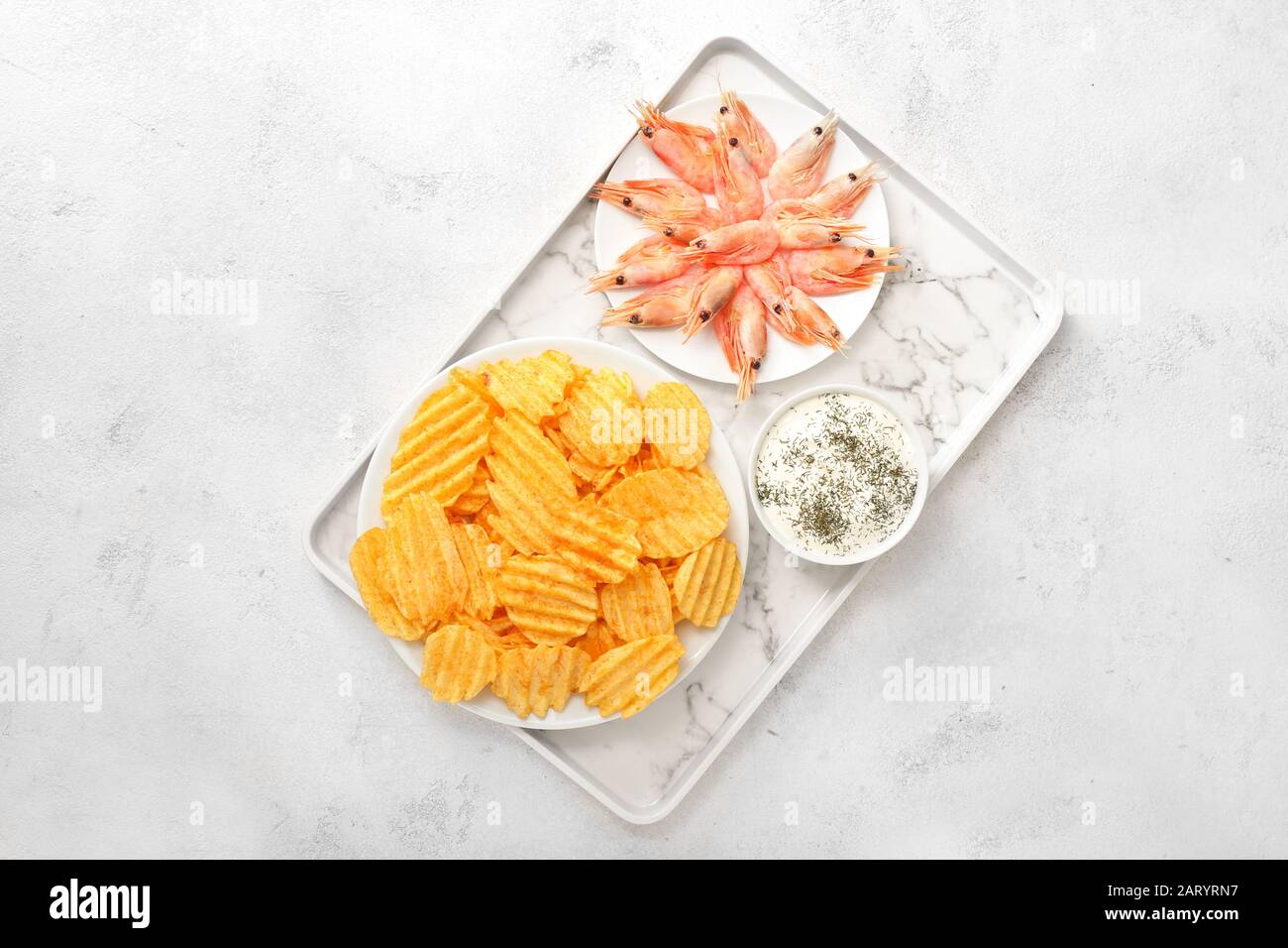 Composition with tasty potato chips and shrimps on light background ...