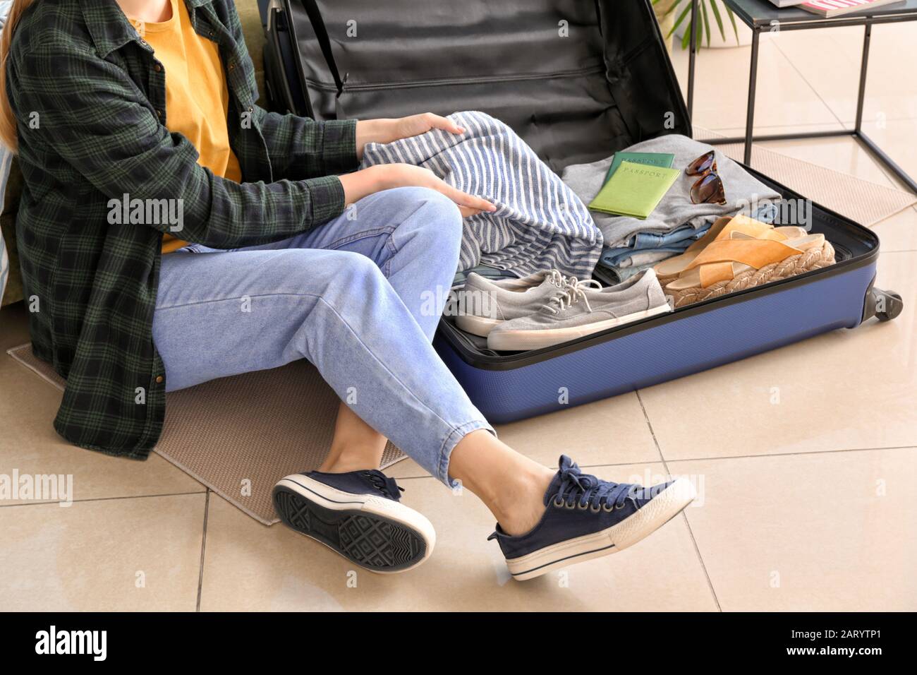 Young woman packing luggage at home Stock Photo - Alamy