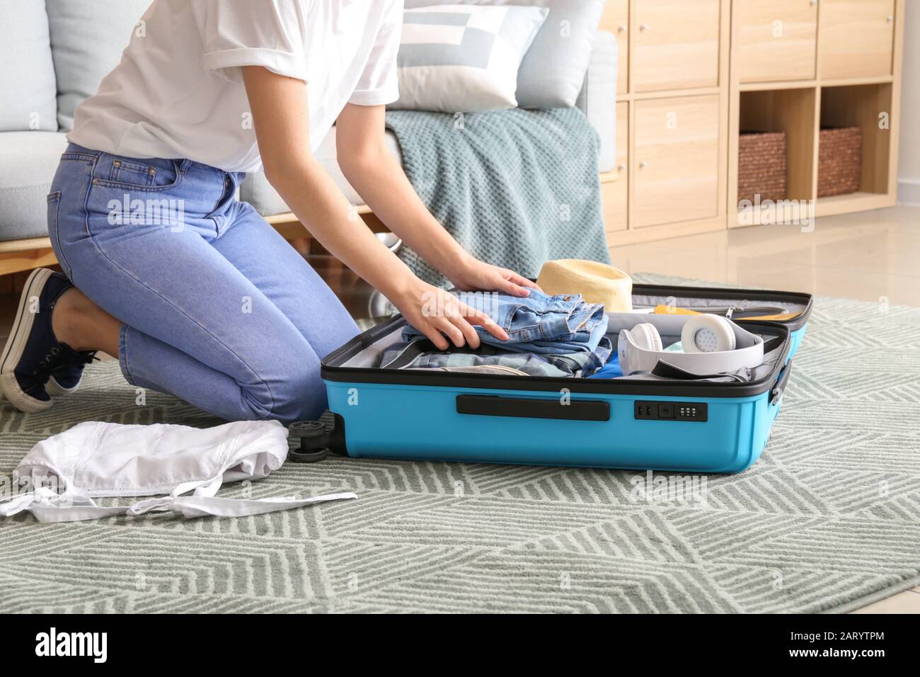Young woman packing luggage at home Stock Photo - Alamy