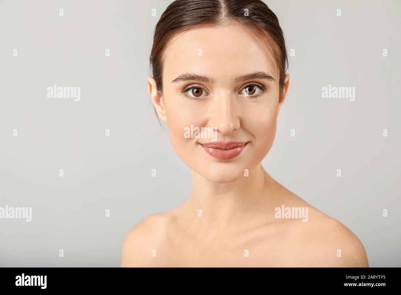 Beautiful young woman with healthy skin on light background Stock Photo ...
