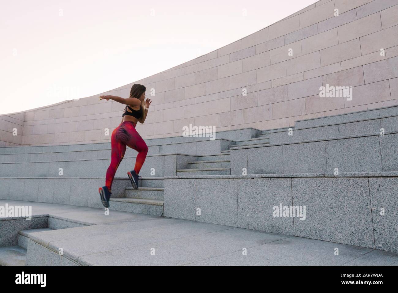 Woman running up steps Stock Photo - Alamy