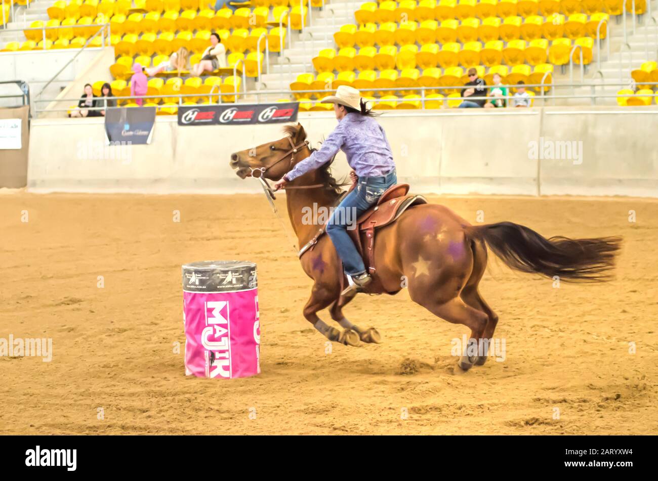 Lady rider competing in a barrel race at an indoor area in Tamworth ...