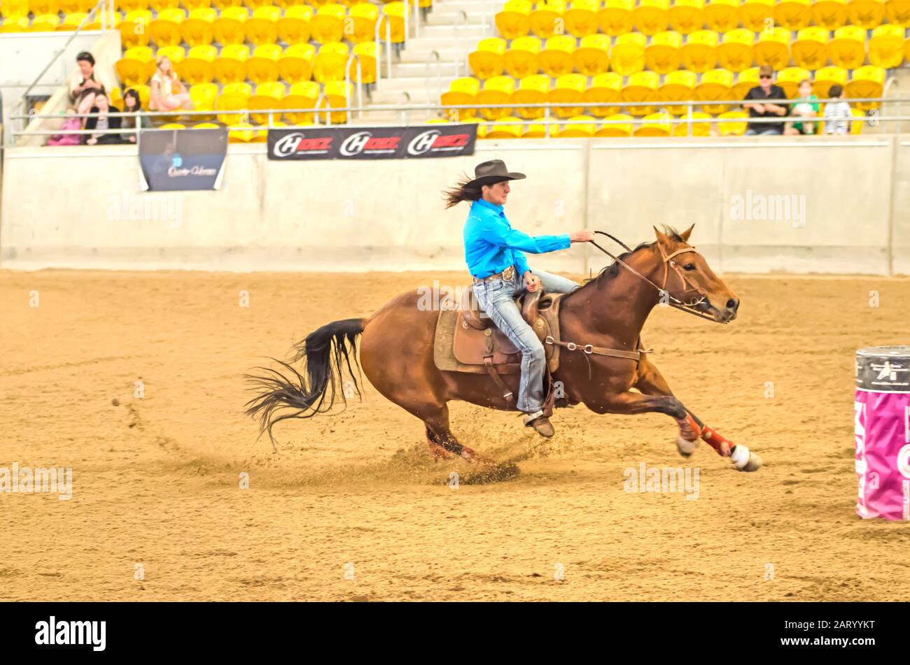 Lady rider approaching a barrel at an indoor arena in Tamworth ...