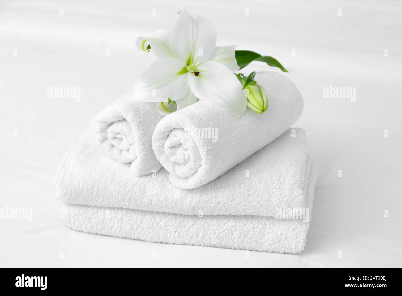 Clean soft towels and flowers on bed Stock Photo - Alamy