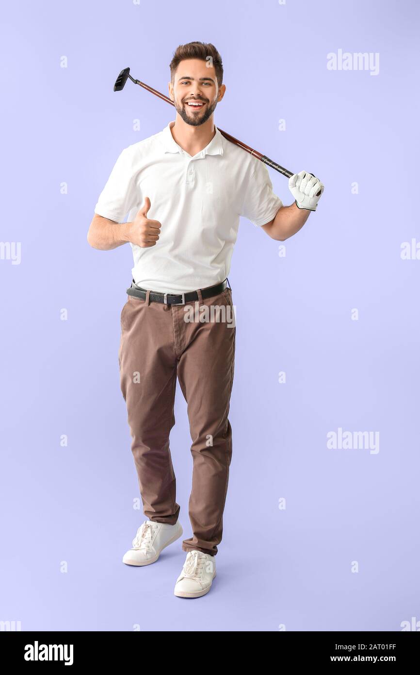 Handsome male golfer showing thumb-up on color background Stock Photo ...