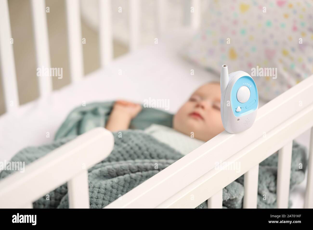 Modern baby monitor on bed with sleeping child Stock Photo - Alamy