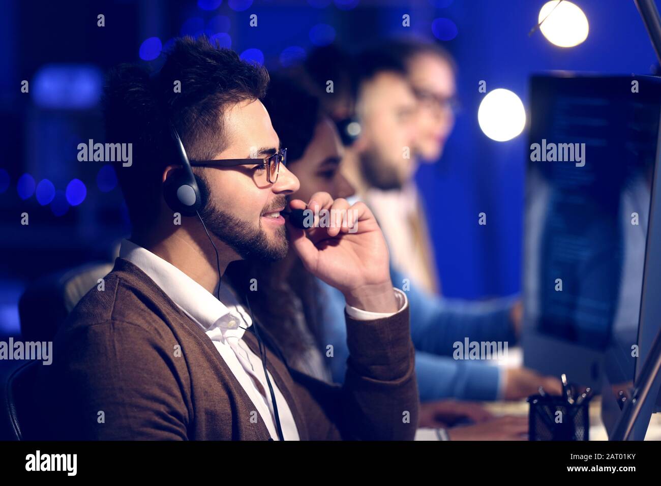 Technical support agents working in office at night Stock Photo - Alamy