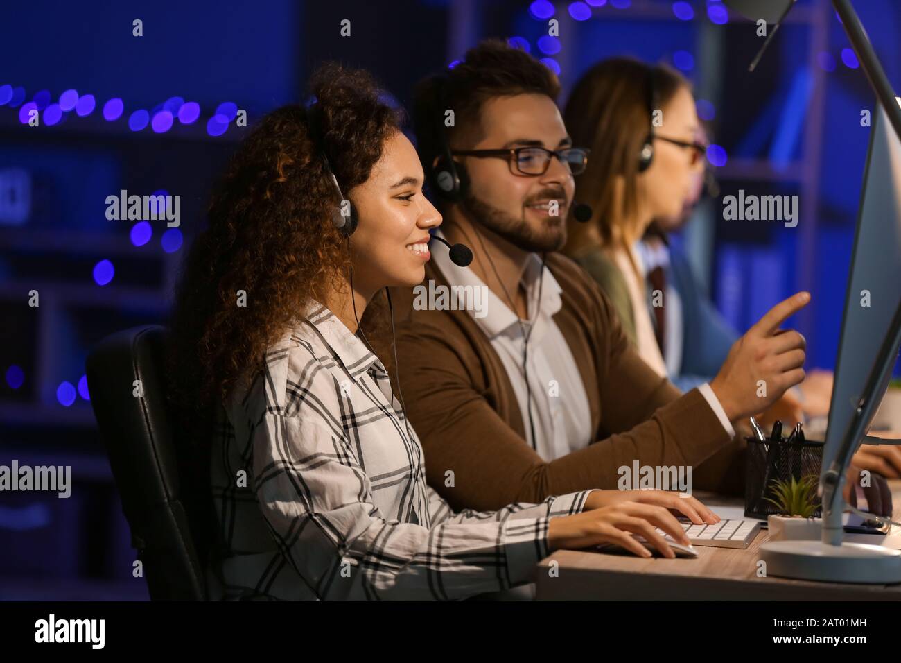Technical support agents working in office at night Stock Photo - Alamy