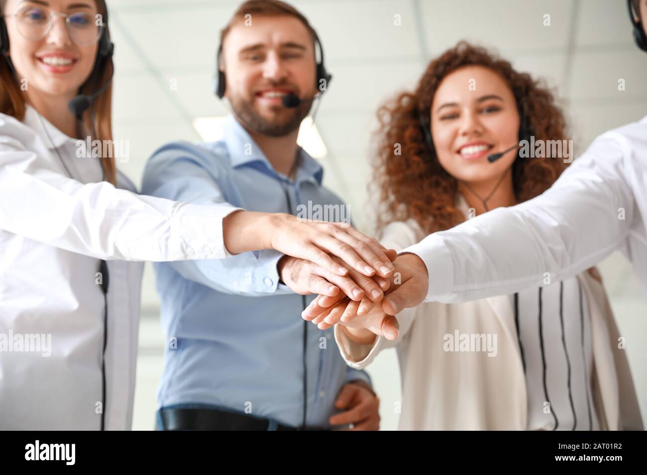 Technical support agents putting hands together in office Stock Photo ...