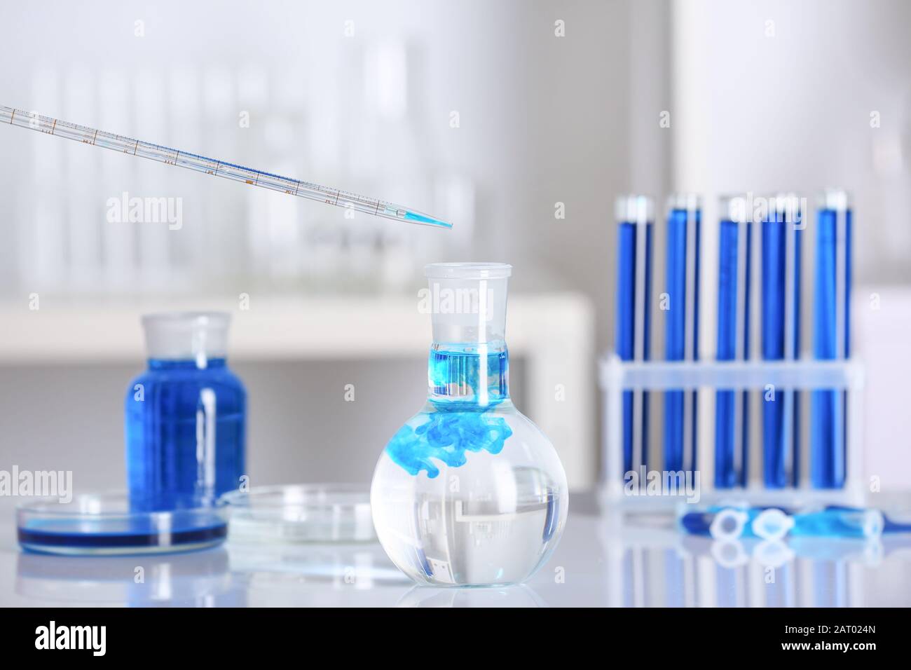 Dripping of color sample into flask in laboratory Stock Photo - Alamy