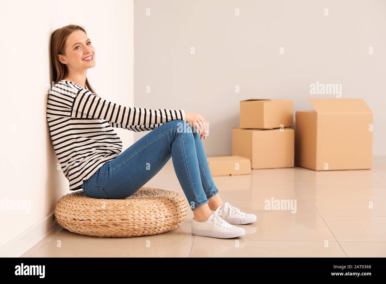 Happy young woman with moving boxes in new house Stock Photo - Alamy