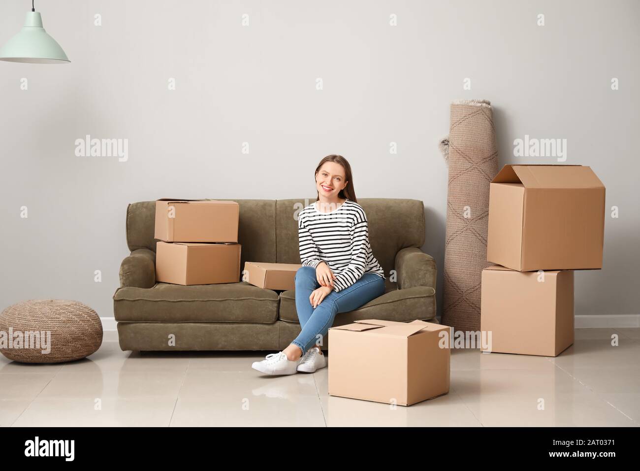 Happy young woman with moving boxes in new house Stock Photo - Alamy