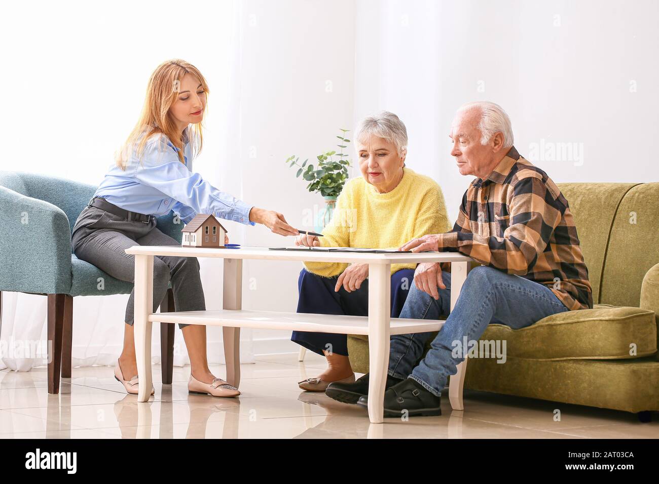 Female real estate agent working with senior couple indoors Stock Photo ...
