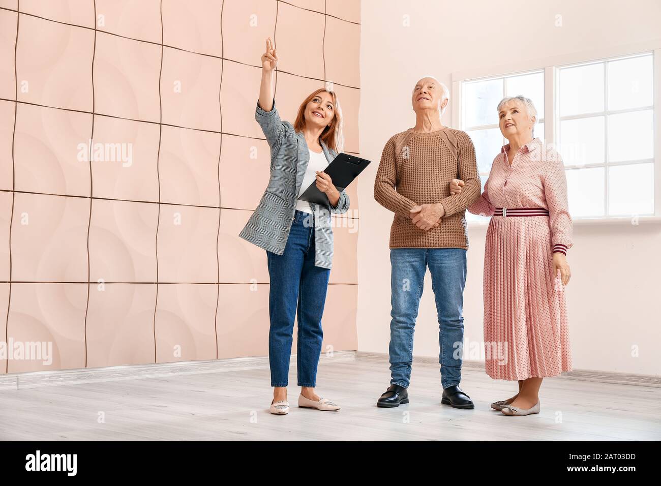 Female real estate agent showing senior couple a new house Stock Photo ...