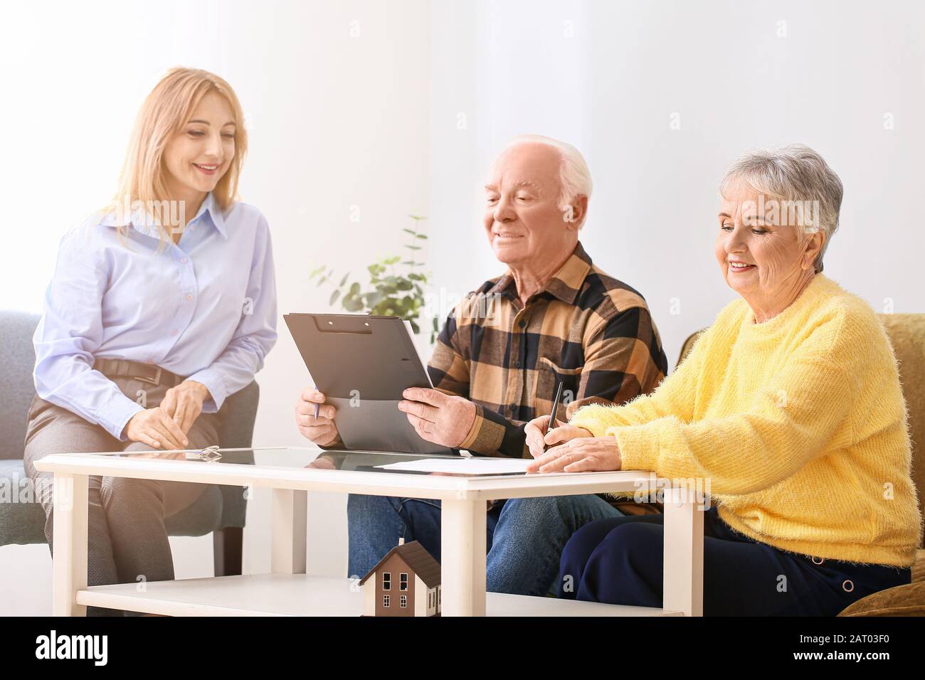 Female real estate agent working with senior couple indoors Stock Photo ...