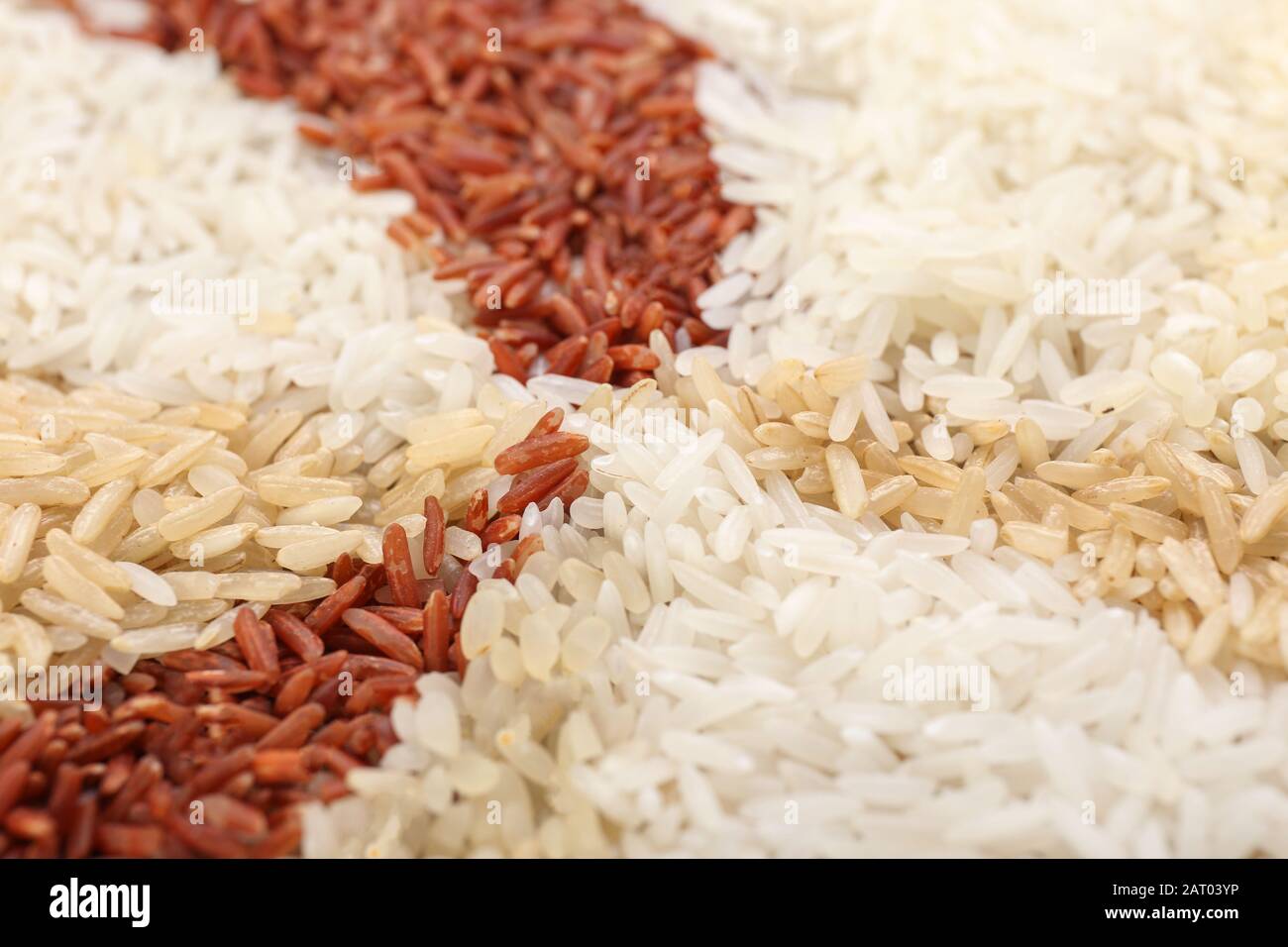 Different raw rice as background Stock Photo - Alamy