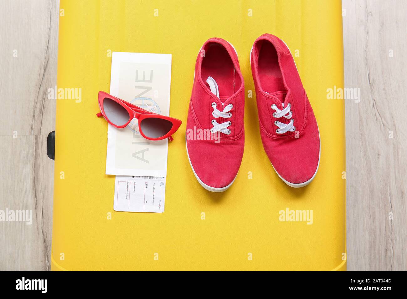 Suitcase with ticket, sunglasses and shoes on floor Stock Photo - Alamy