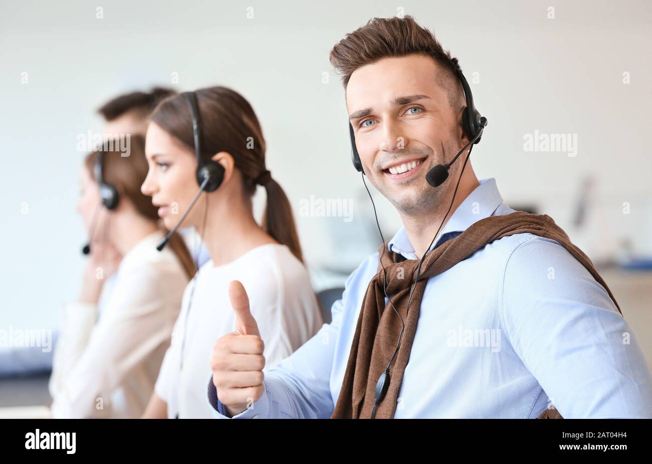 Male technical support agent showing thumb-up gesture in office Stock ...