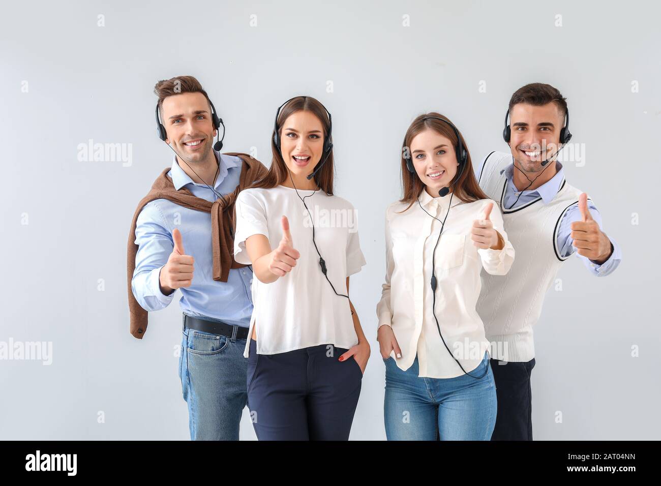 Team of technical support agents showing thumb-up gesture on white ...