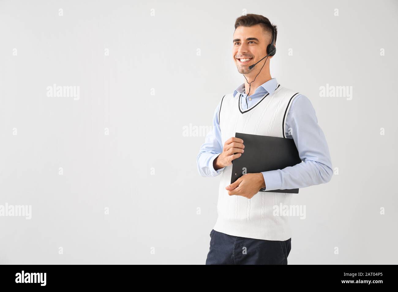 Male technical support agent on light background Stock Photo - Alamy