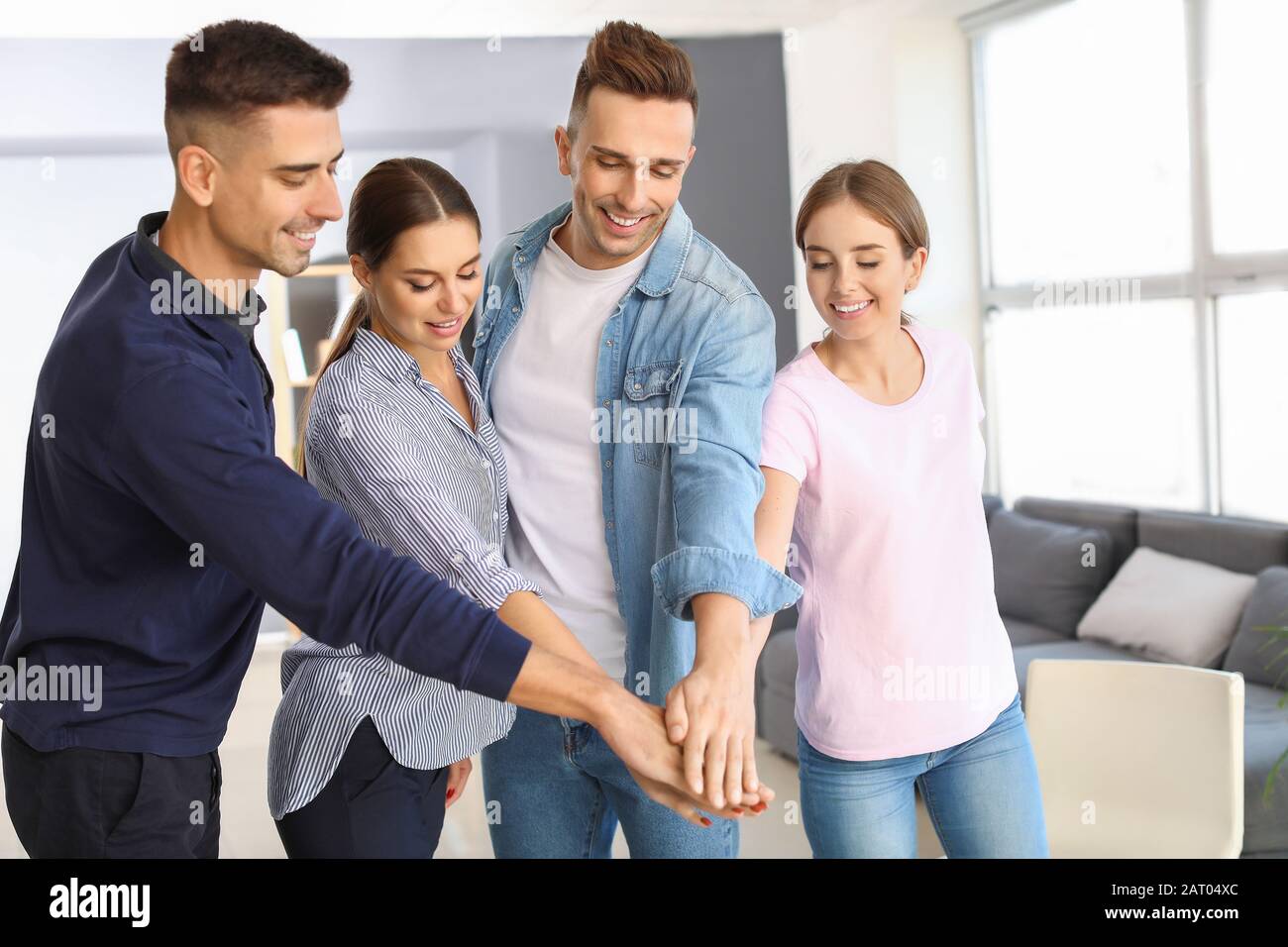Young people putting hands together during psychological support ...