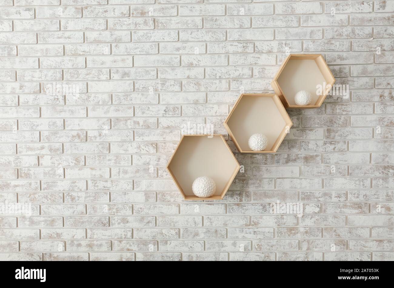 Shelves with decor hanging on brick wall Stock Photo - Alamy