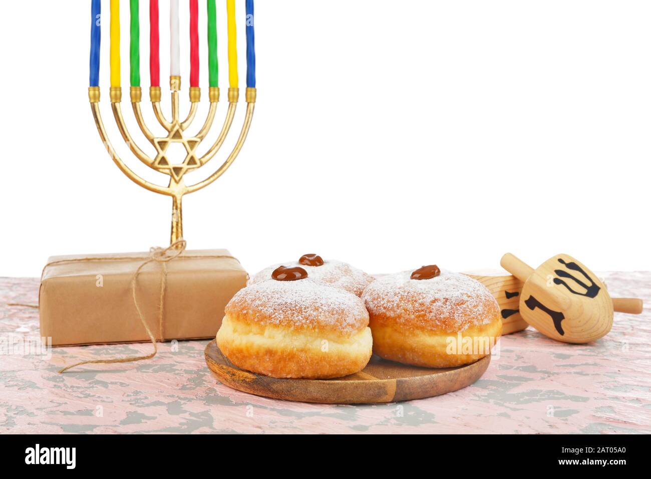 Menorah, donuts for Hanukkah, gift and dreidels on table against white ...