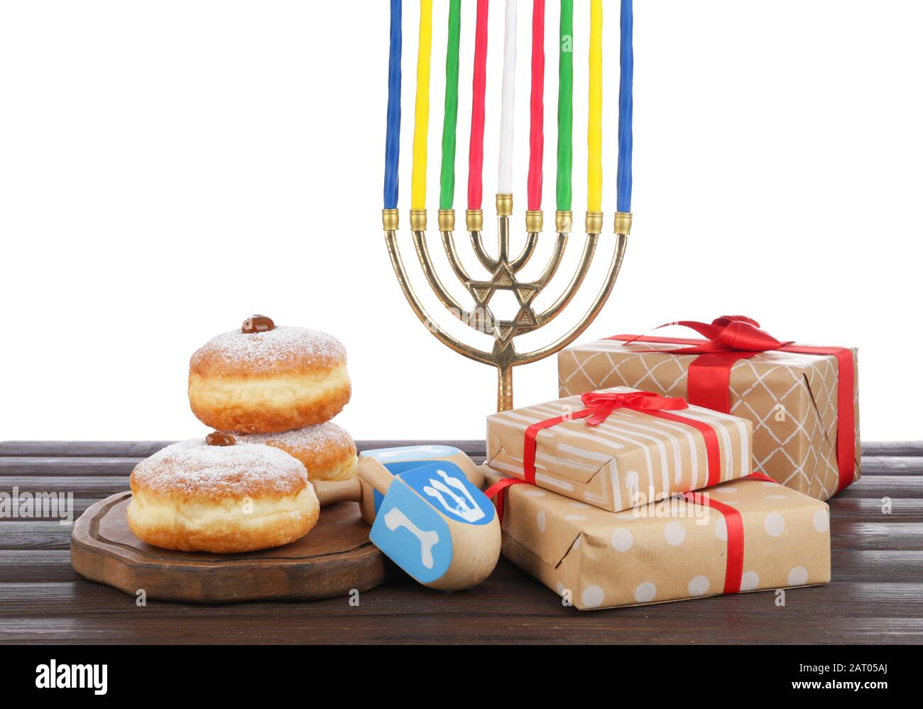 Menorah, gifts, donuts for Hanukkah and dreidel on table against white ...