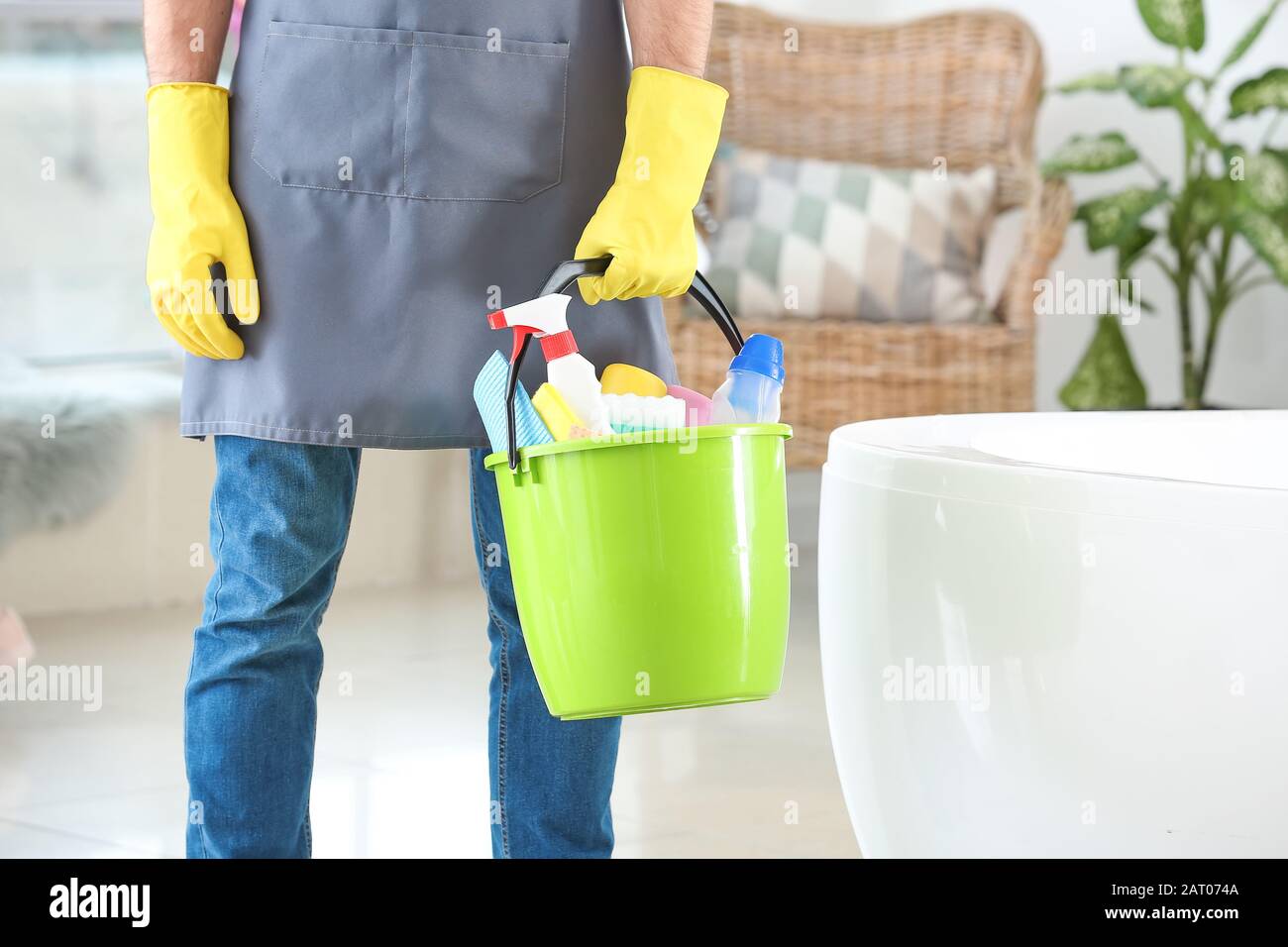 Janitor with cleaning supplies in bathroom Stock Photo - Alamy