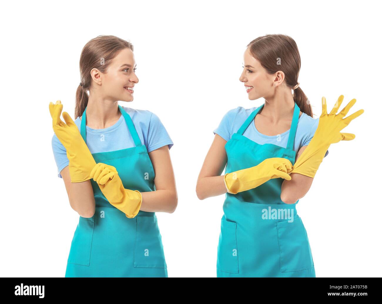 Female janitors putting on rubber gloves against white background Stock ...