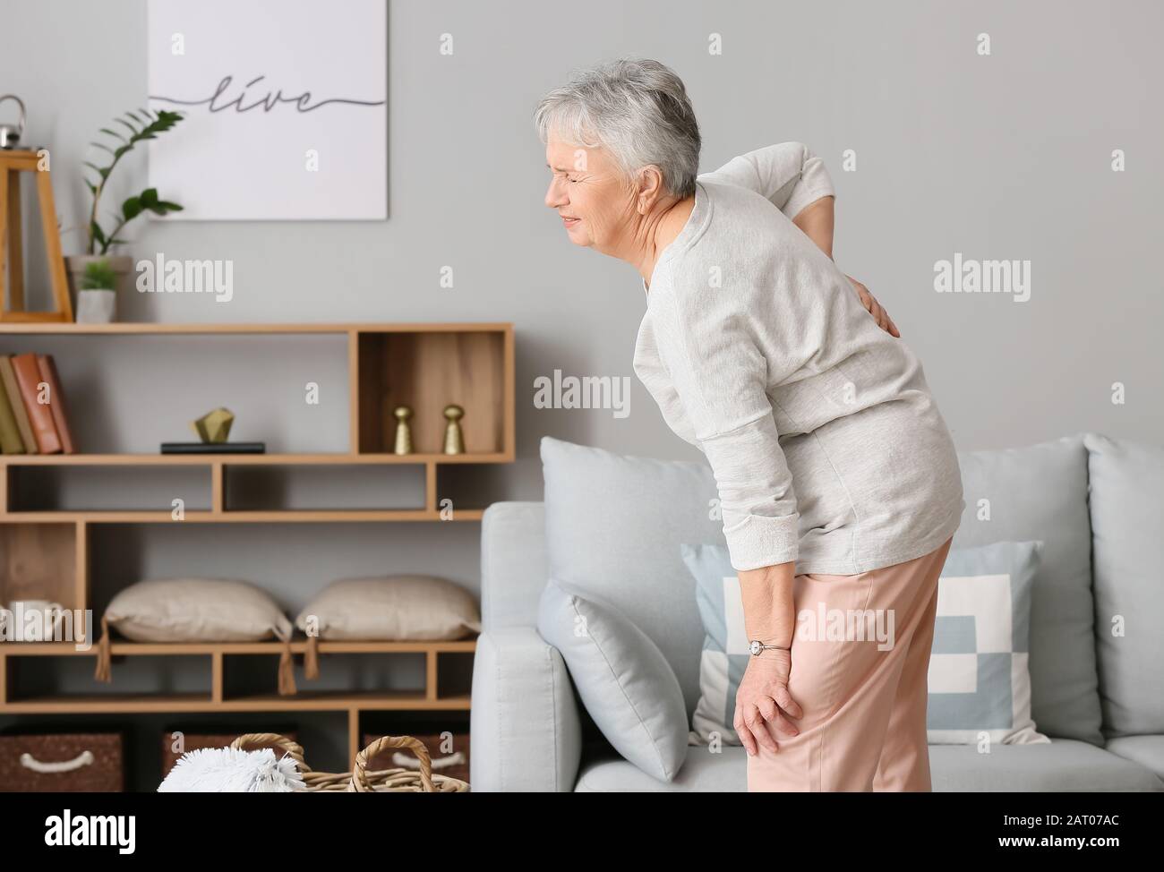 Senior woman suffering from back pain at home Stock Photo - Alamy