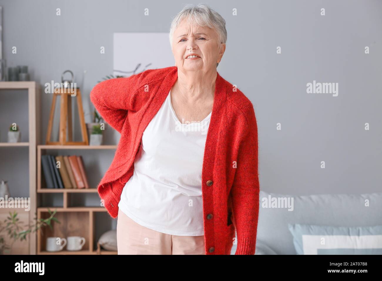 Senior woman suffering from back pain at home Stock Photo - Alamy