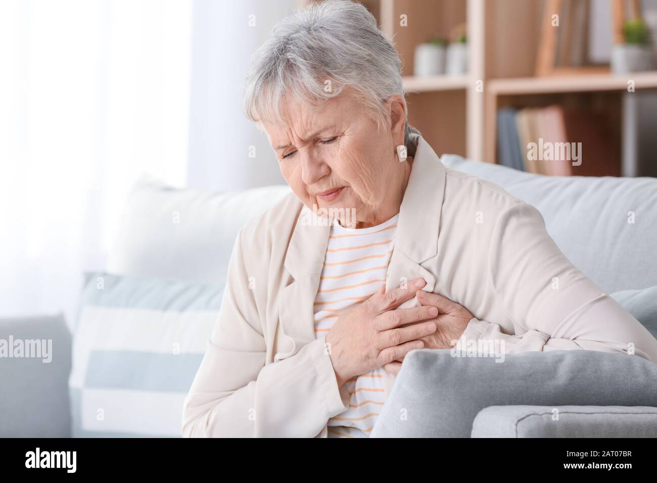Senior woman suffering from heart attack at home Stock Photo - Alamy