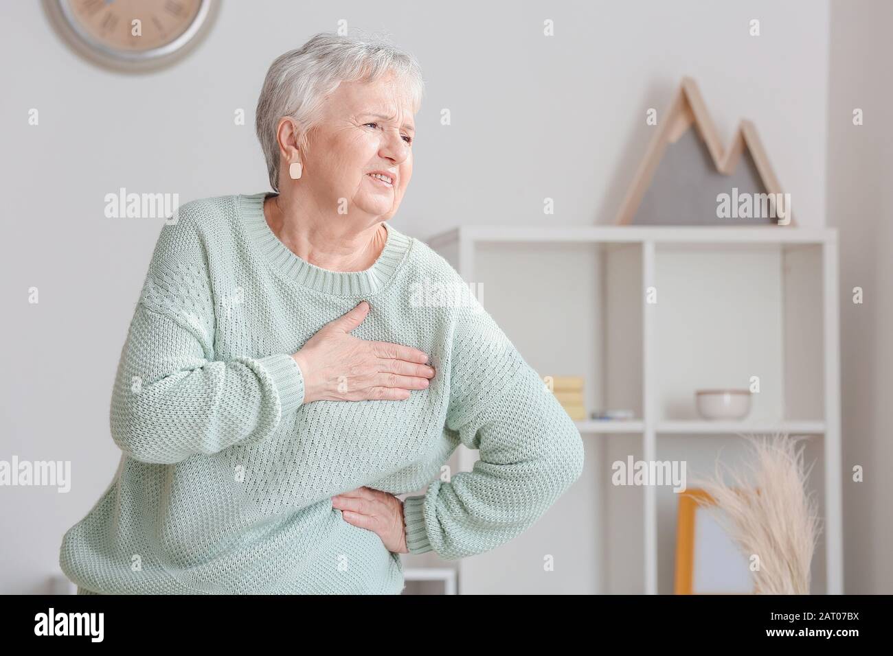 Senior woman suffering from heart attack at home Stock Photo - Alamy